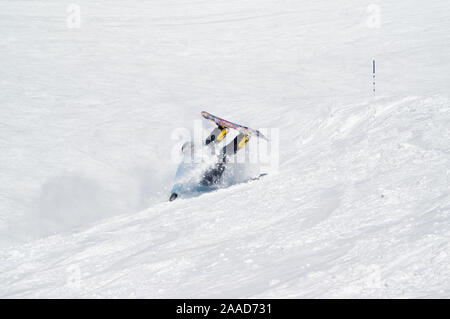Snowboarder fall down with snow splashes on snowy ski slope and chair ...