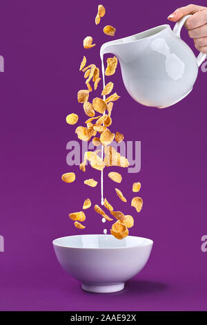 Falling granola with milk splash from dipper. Healthy breakfast ...