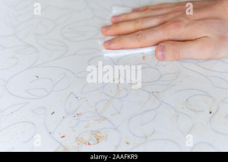 hand with a white rag wiping the dirty table surface in the kitchen at ...