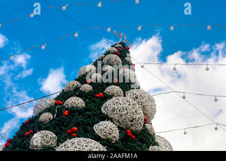 A giant Christmas tree with golden decorations is displayed outside a ...