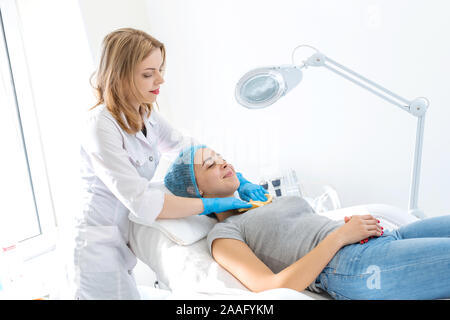 beautician cleanses skin of beautiful woman with a sponge Stock Photo ...