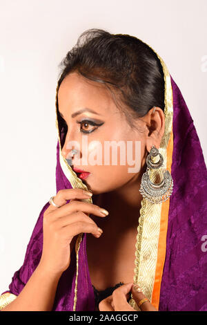 Close up of an beautiful Indian Girl wearing traditional big golden ...