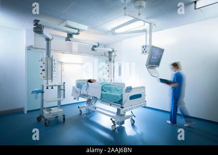 Intensive care unit in a hospital. A patient is connected to different ...