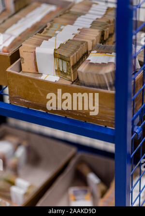 Stacks of banknotes with currency straps put in boxes in blue metal ...