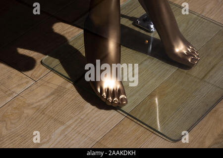 gold manikin feet in ladies fashion shop window display Stock Photo - Alamy