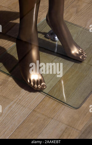gold manikin feet in ladies fashion shop window display Stock Photo - Alamy