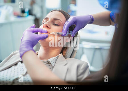 Woman is getting rejuvenating facial injections. The expert beautician ...