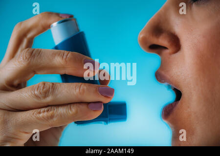 Woman with asthma using pump inhaler Stock Photo - Alamy