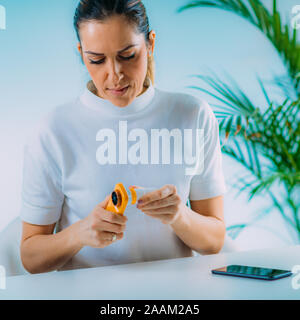 A woman using a Application on her phone while having coffee in a ...