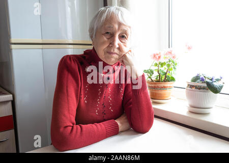 Elderly lonely woman depressed sitting at the table at home Stock Photo ...