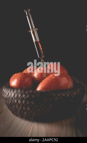 Injection of poisonous toxin into an organic tomato Stock Photo - Alamy