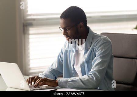 Smiling male employee work texting at pc in office Stock Photo - Alamy