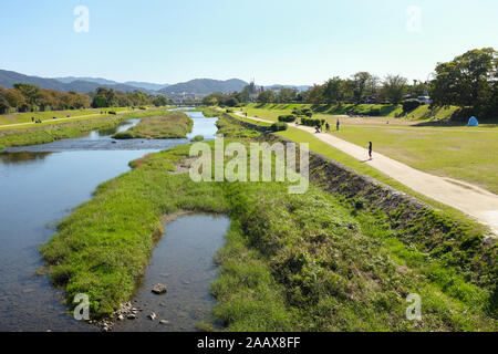The Kamo River, in Kyoto, Japan, in winter. The riverbanks are popular ...