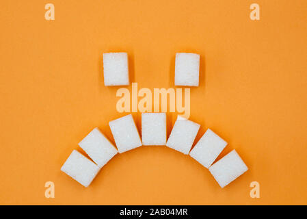 Sad face symbol, composed of cubes of sugar Stock Photo - Alamy