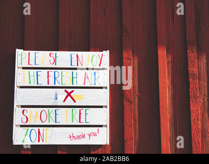 Please enjoy the fresh air smoke free zone sign attached to timber café ...