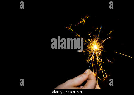 Hand holding a sparking match stick. Black background Stock Photo - Alamy