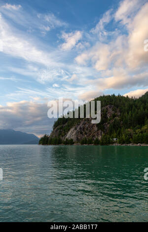 A beautiful view of the sea surrounded by green tree-covered mountains ...