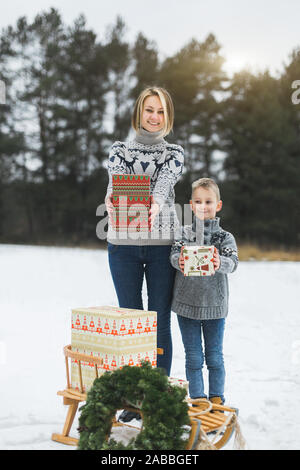 Winter holidays and gifts concept. Funny redhead girl looking inside ...