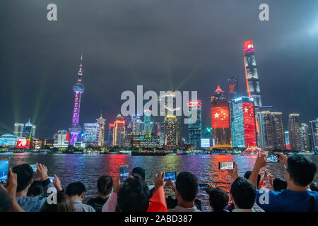 Tourists gather at the Bund to enjoy the light show performed with ...