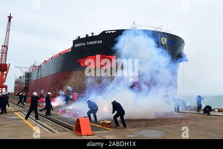 Workers set fireworks to celebrate the completion of the bulk cargo ...