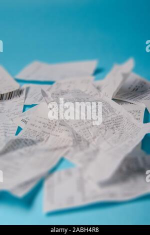 Pile of shopping receipts on a blue background Stock Photo - Alamy