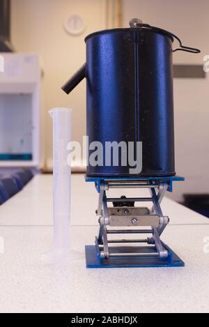 Spouting can with measuring cylinder of water to measure the density of ...