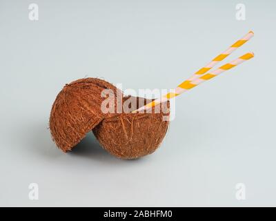 coconut with a drinking tube on a light blue background, close-up ...