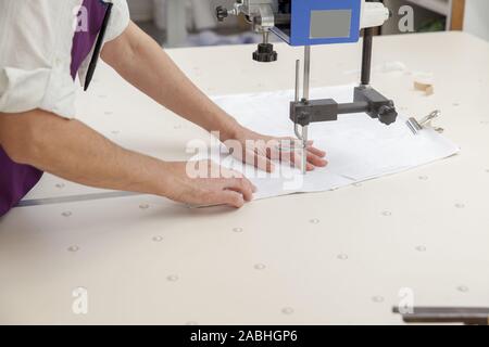 cuts material with textile knife, close up Stock Photo - Alamy