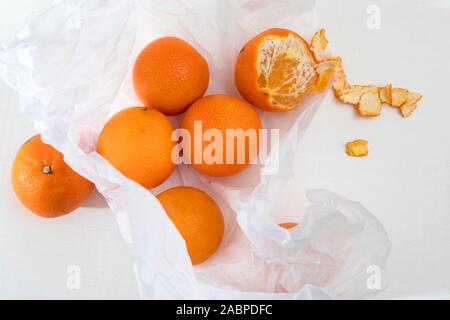 Tangerines in yellow crumpled craft paper on a dark wooden kitchen ...