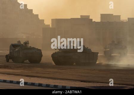Army tanks shooting and driving in the desert town in war and military ...