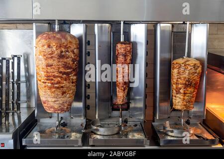Turkish shawarma roasting on vertical skewer Grilled skewered chicken ...