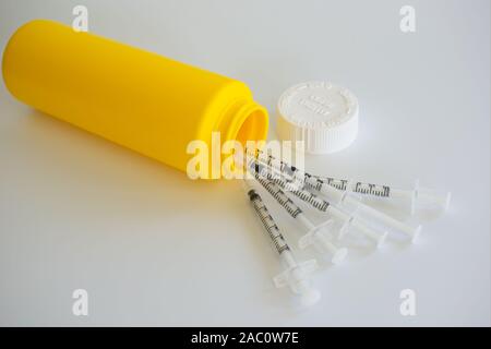 Hospital sharps syringe needle disposal container mounted on a wall ...