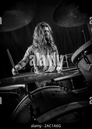 Young long-haired drummer playing his drum set during a concert Stock ...