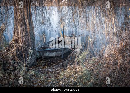 a lonely rowing boat lies on the shore of a lake Stock Photo - Alamy