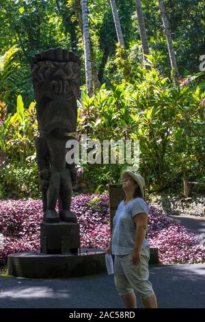 A carved wooden statue of the Hawaiian god Ku centers the banyan canyon ...