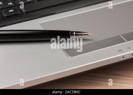 Black ballpoint pen lies on red blue background Stock Photo - Alamy
