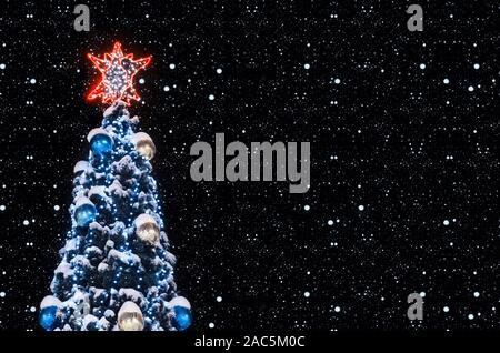 Christmas tree bulbs with yellow garlands covered snow, outdoor xmas ...