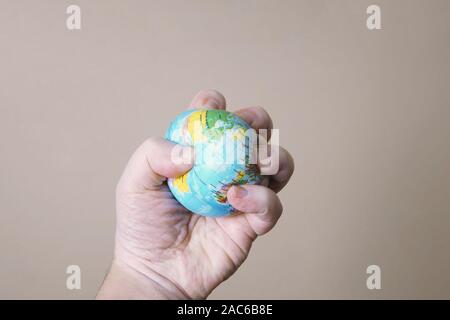 ecocide concept - hand crushing or squashing globe of planet earth ...