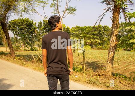 Backside of a young boy wearing black t shirt simple natural get up ...