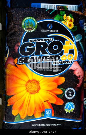 A stack of bags of Growmore Seaweed Compost in a farm shop in North ...