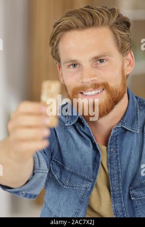 handsome young man eating cereal bar Stock Photo - Alamy