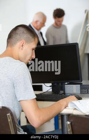 Handsome male student doing task Stock Photo - Alamy