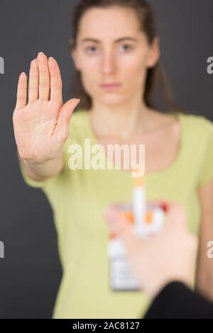 Stop smoking concept. Woman refusing cigarettes on grey background ...