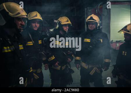 Team of firefighters standing inside ( indoors ) a buliding next to a ...