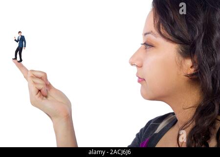 A giant hand holding a tiny businessman near a box full of three other ...