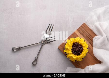 Beautiful sunflower decorated chocolate cupcake on dark wood background ...