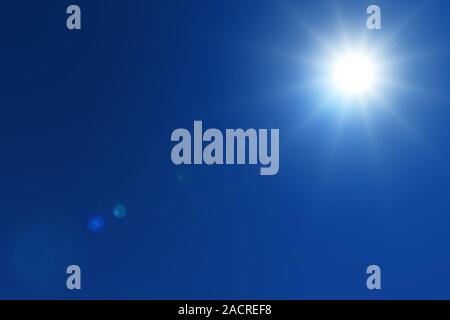 Sun with glare spots in a blue sky Stock Photo - Alamy