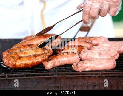 Sausages on the burning grill grate and tongues of fire flame Stock ...