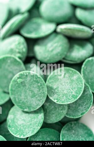 Green round chocolate chips for melting chocolate shapes on a white ...
