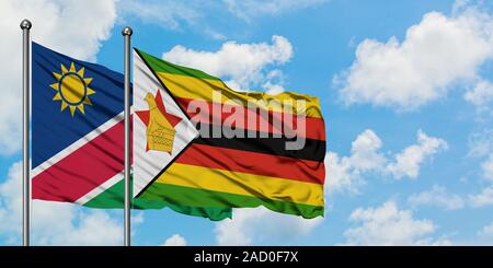 Zimbabwe and Namibia flag waving in the wind against white cloudy blue ...